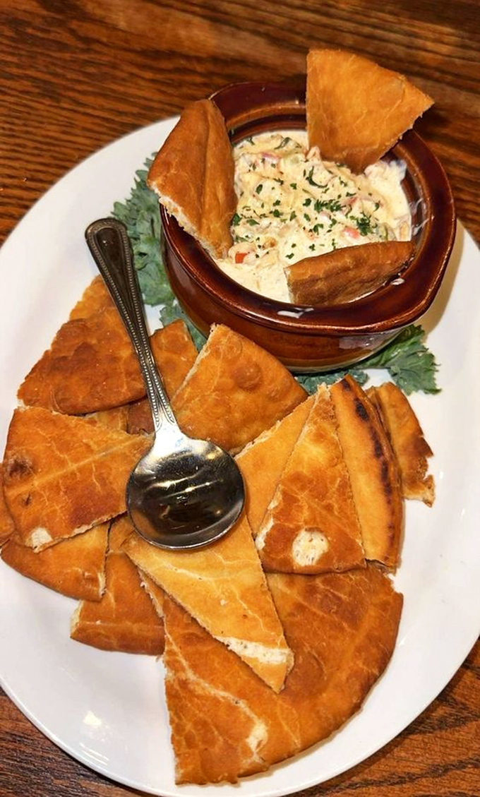 Hot crab dip surrounded by crispy triangles of pita – a shareable starter that tests friendships when the last scoop is at stake.