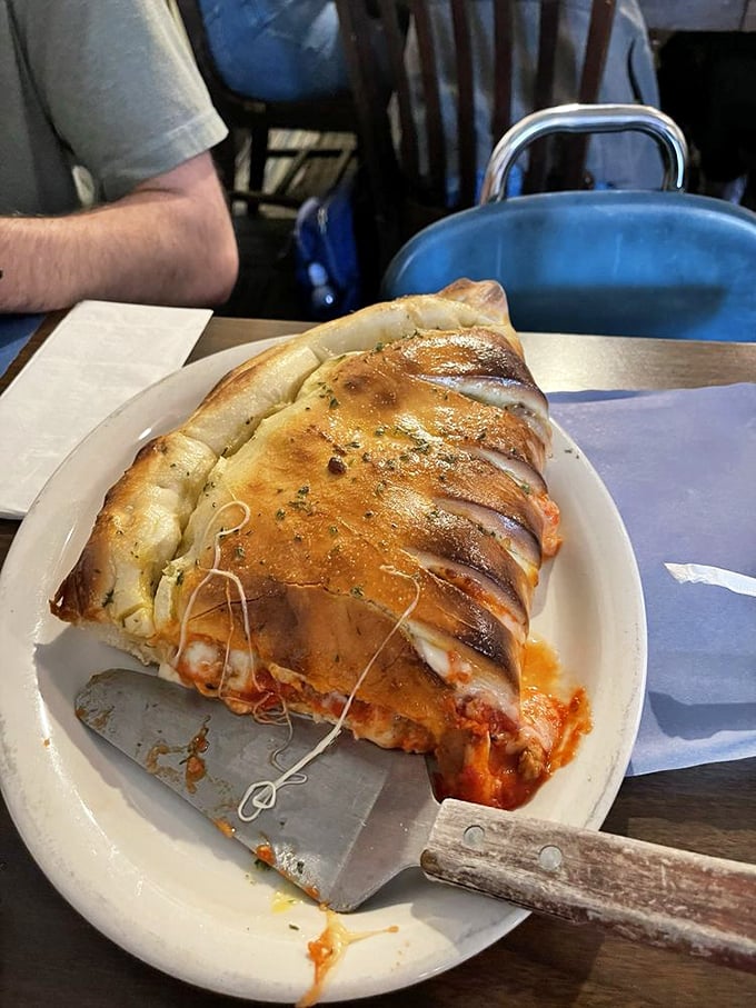 This isn't just a calzone&mdash;it's a golden-brown fortress protecting a treasure of cheese, sauce, and fillings. Worth the 45-minute wait.