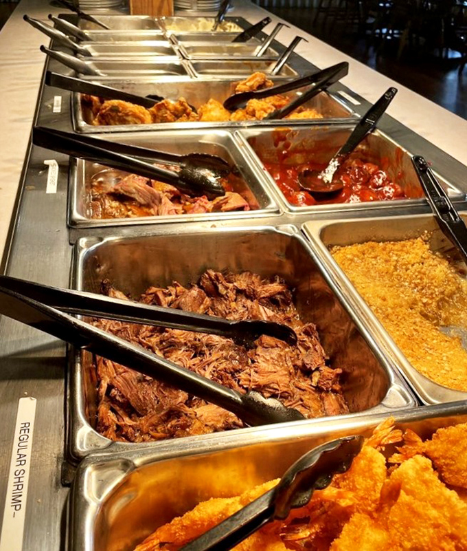 The buffet of champions. Each metal tray contains not just food, but edible joy waiting to be scooped onto eager plates.