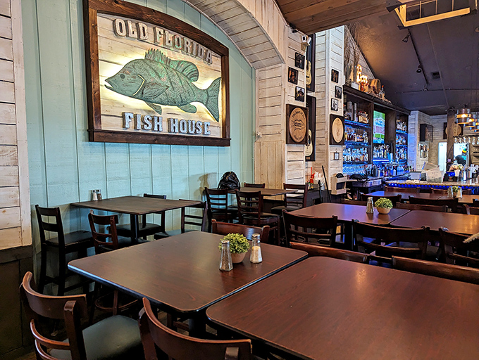 Coastal-chic meets Old Florida charm with weathered wood walls and fish artwork that doesn't try too hard. Comfort wears a blue collar here.
