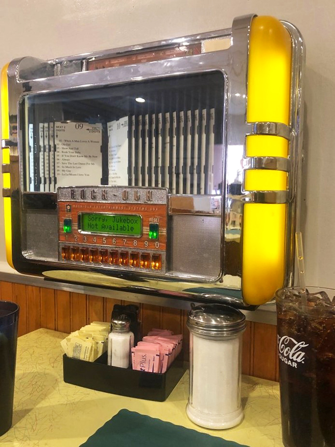 A vintage jukebox that still plays the soundtrack to your parents' first date, standing sentinel beside packets of sugar and classic diner creamers.