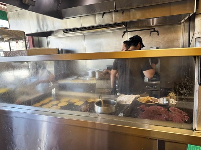 Behind the steamy glass, tortillas dance on the griddle while meat sizzles in anticipation of its destiny.