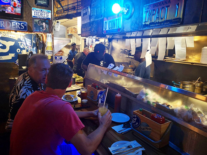 Where culinary magic happens behind a counter lined with license plates. The steam rising isn't just from cooking – it's applause from the ingredients.