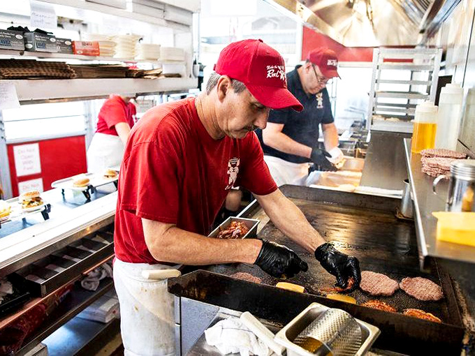 The grill masters at work&mdash;where burger flipping isn't just a job, it's performance art with delicious consequences. 