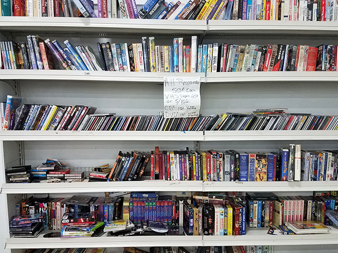 These shelves offer a glimpse into media history, where DVDs and books create a physical library that streaming services can't replicate.