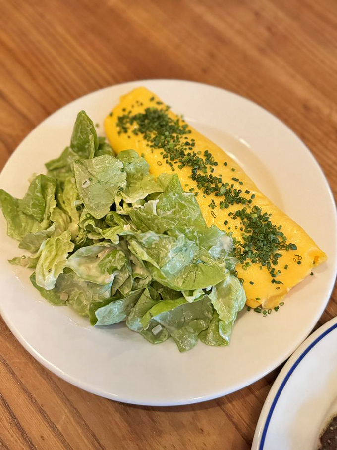The perfect French omelette is deceptively simple yet maddeningly difficult to master. This golden pillow of eggs with fresh herbs represents culinary technique at its finest.