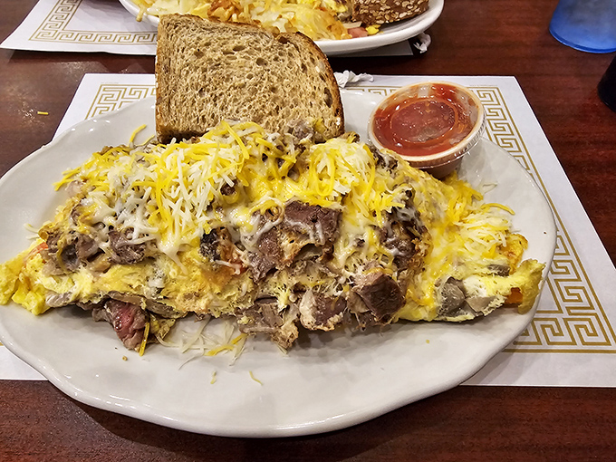 This isn't just an omelet&mdash;it's a cheese-covered monument to breakfast excellence. The toast stands by, ready for its supporting role.