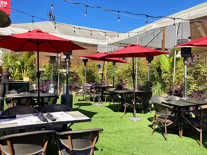 The outdoor patio &ndash; where California sunshine meets steakhouse sophistication. Red umbrellas stand guard against the rare raindrop.