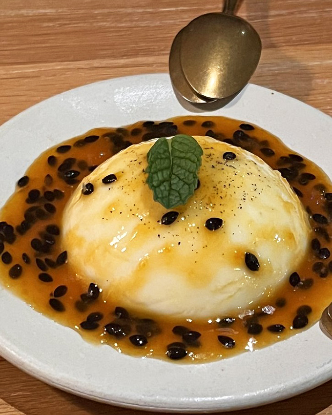 A panna cotta surrounded by passion fruit and balsamic pearls that looks like modern art but tastes like your grandmother's love—if she were an Italian culinary genius.
