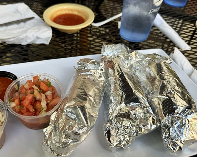 Foil-wrapped treasures flanked by fresh pico de gallo&mdash;the silver packages aren't just tacos; they're gifts your taste buds have been patiently waiting to unwrap.