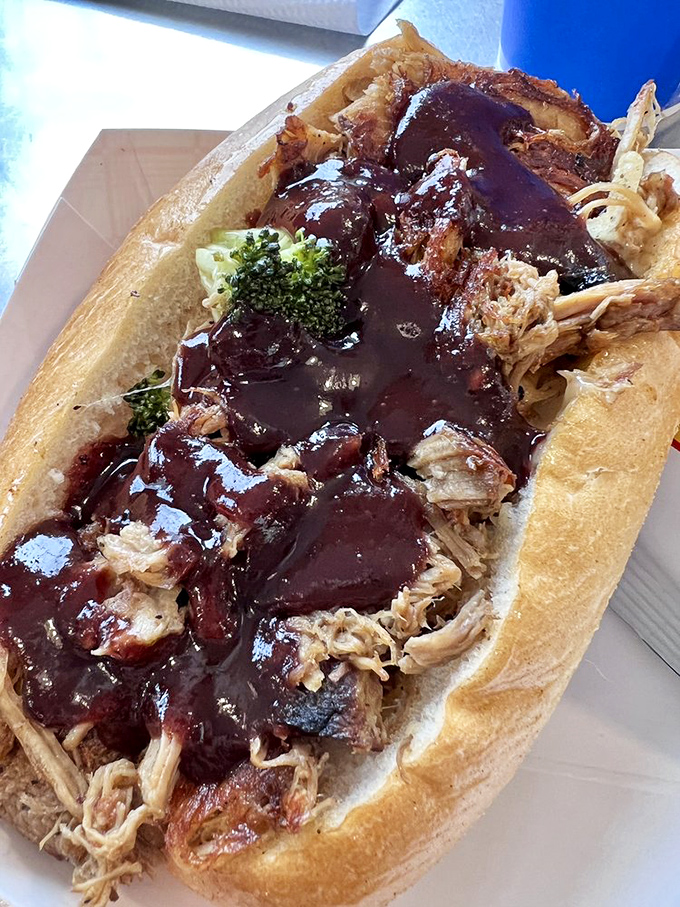 This pulled pork sandwich isn't messing around. That sauce means business, and the broccoli garnish is making a valiant attempt at balance.