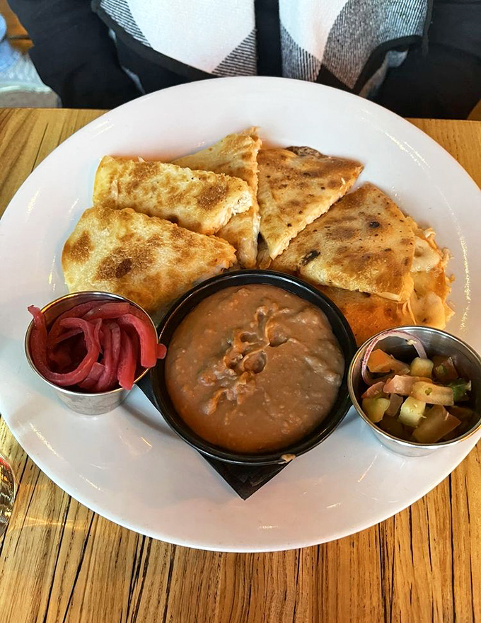 A quesadilla that's achieved the perfect golden crust, served with pickled onions that cut through the richness like a magenta lightning bolt.