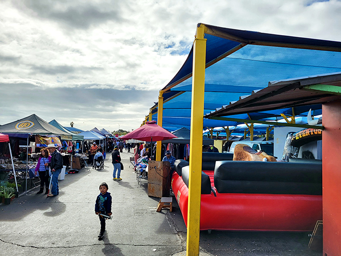 Blue canopies create makeshift boulevards where families navigate the market's maze, each aisle promising new discoveries around every corner.