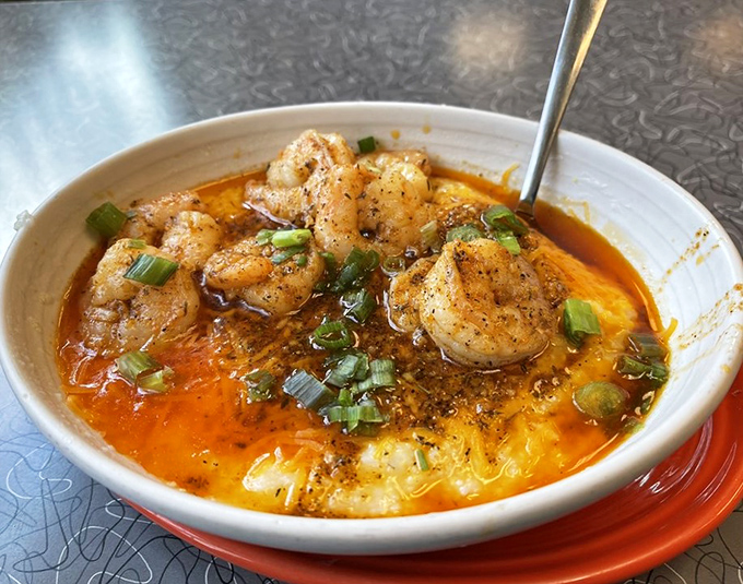 Shrimp and grits that would make a Southerner nod in approval. That orange-hued sauce isn't just pretty—it's carrying enough flavor to power a locomotive.