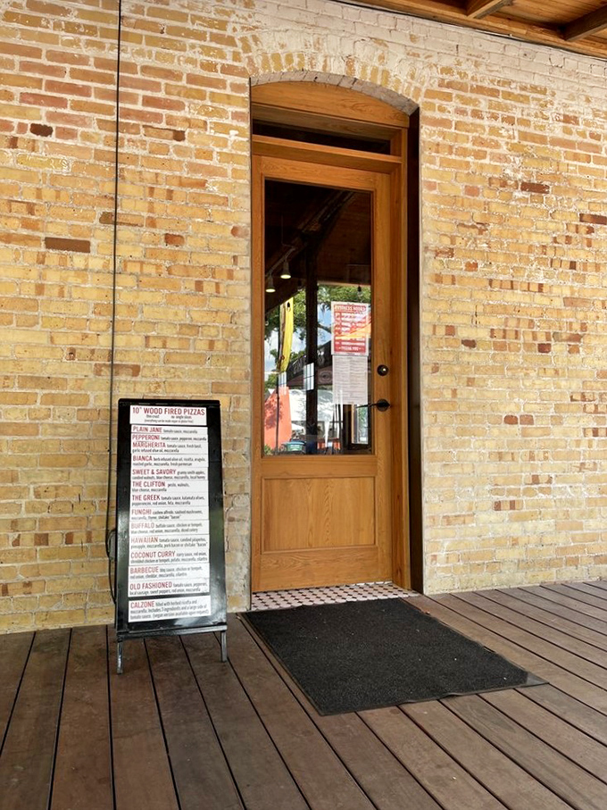 Even the side entrance whispers promises of the wood-fired wonders waiting just steps away inside.