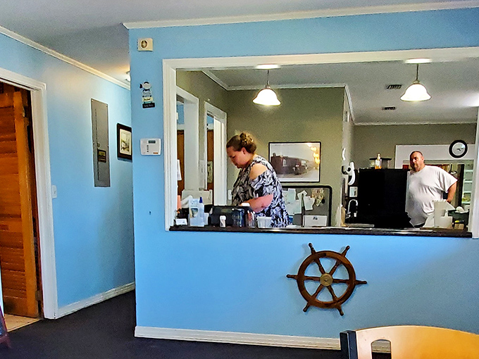 Behind every great seafood restaurant is a dedicated kitchen crew. The ship's wheel at the counter reminds you who's steering this culinary voyage.
