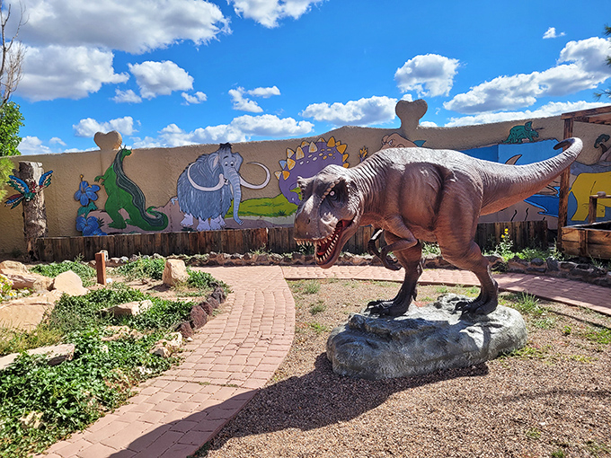 This T-Rex stands guard against a backdrop of prehistoric murals, looking surprisingly photogenic for a creature with such tiny arms.