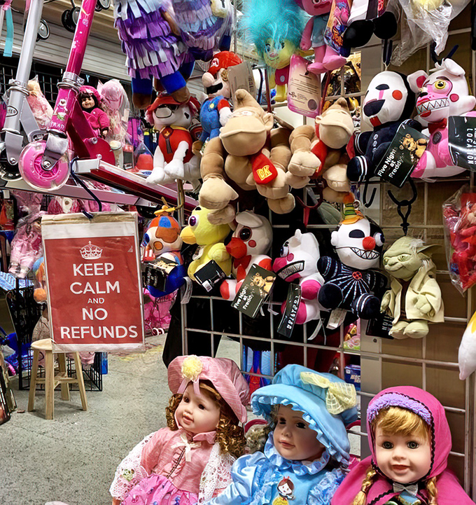 Dolls and plush toys create a slightly unnerving welcoming committee, while the "No Refunds" sign offers the day's only certainty.