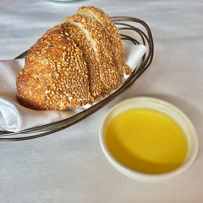 Bread that deserves its own fan club. This seeded sourdough with golden olive oil isn't just a starter &ndash; it's the opening act of a rock concert.