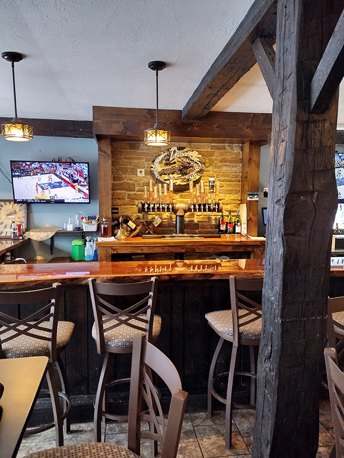 The bar area blends rustic charm with modern comforts, where craft beers flow and stories are exchanged beneath centuries-old wooden beams.