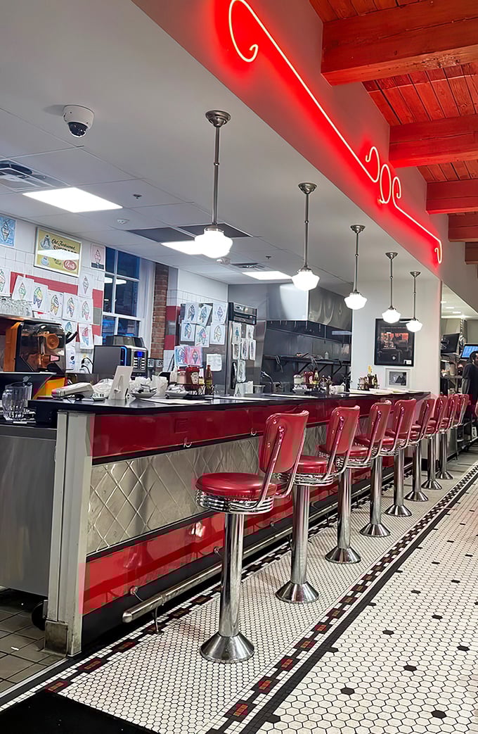 The counter where magic happens&mdash;gleaming red stools invite you to sit and watch soda jerks orchestrate sweet symphonies beneath neon glow.