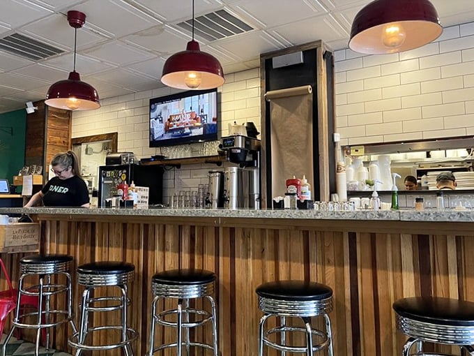 The bar area offers front-row seats to the breakfast ballet. Those red pendant lights aren't just illuminating the space &ndash; they're setting the mood.