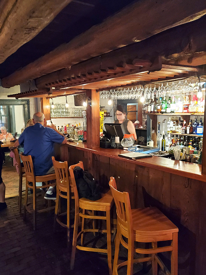 A bar that understands the difference between trendy and timeless. Wine glasses hanging above like crystal stalactites in a cave of conviviality.