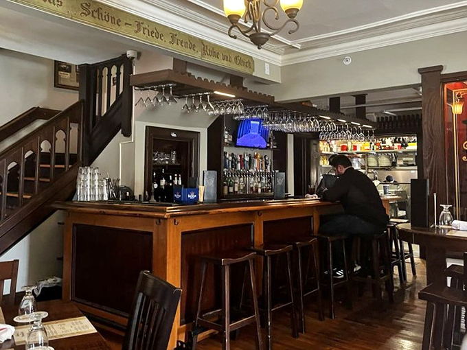 The bar area features hanging glassware and German inscriptions above&mdash;a place where "Prost!" replaces "Cheers!" and beer is treated with proper reverence.