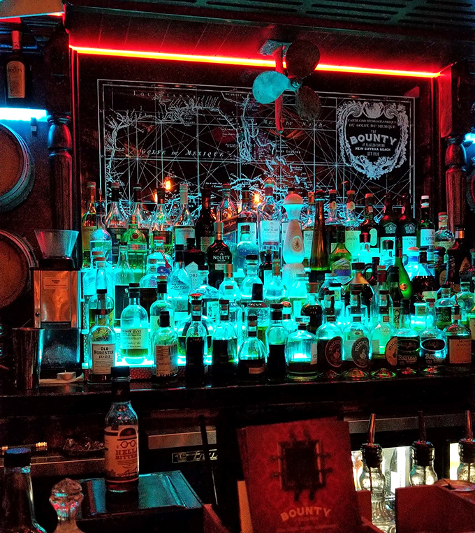 The bar glows with possibility. Backlit bottles create an aquatic ambiance that perfectly complements the maritime theme and craft cocktail program.