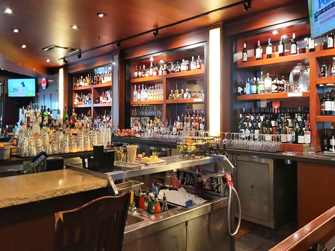 A bar stocked for serious business. The amber glow of bourbon bottles promises complex flavors that pair perfectly with anything off the grill.