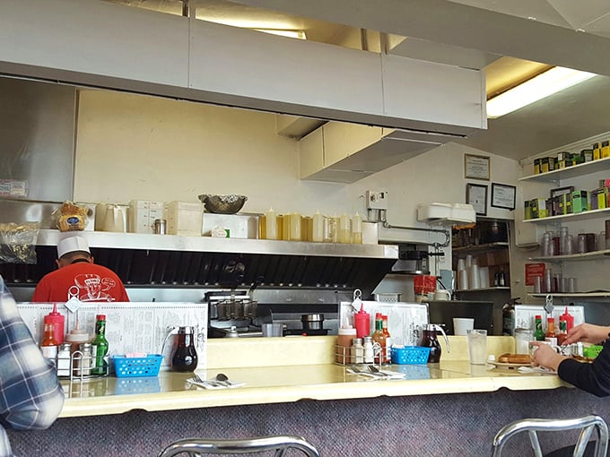 The open kitchen setup lets you witness the choreography of short-order cooking, where spatulas move with the precision of surgical instruments.