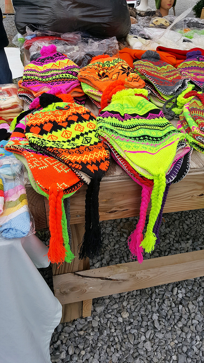 Neon knit hats explode with color against the wooden table. These aren't just winter warmers&mdash;they're wearable art with personality to spare.