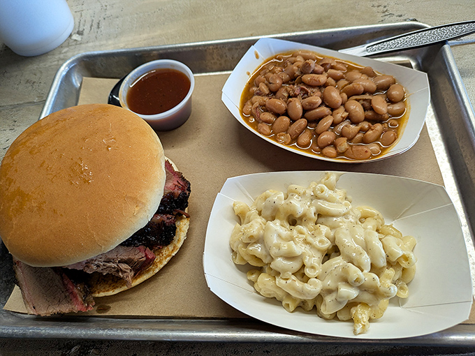 The holy trinity of Texas comfort: a brisket sandwich, pinto beans swimming in savory broth, and mac and cheese that means business.