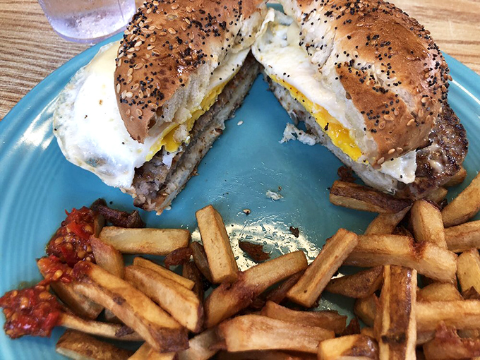 The breakfast sandwich cut in half reveals its secrets&mdash;a perfectly cooked egg and savory meat nestled between a toasted everything bagel. 