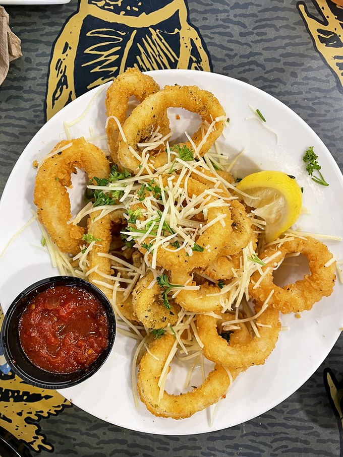 Golden calamari rings that crunch like nature's perfect snack food, with marinara standing by for that essential tangy dunk.