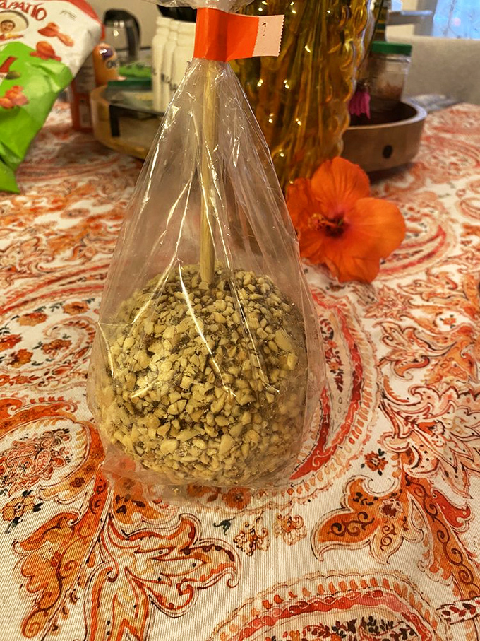 A caramel apple wearing a nutty tuxedo – because even fruit deserves to dress up sometimes.