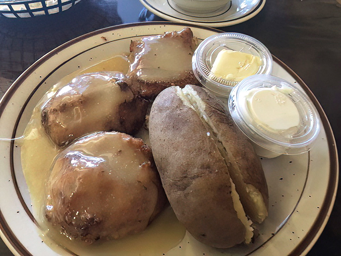 Golden-brown biscuits swimming in gravy, with a baked potato standing by for moral support. Carb-counters, look away—this is where diet plans come to die happily.