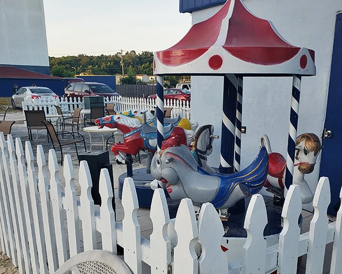 A miniature carousel behind white picket fencing&mdash;because the Ocala Drive-In understands that sometimes the little ones need entertainment before the big show begins.