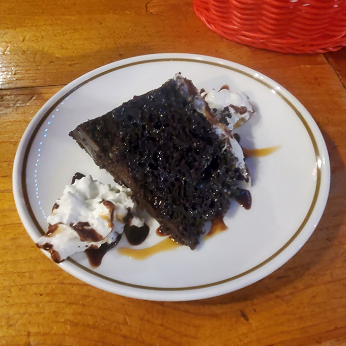 Chocolate cake so rich it probably owns real estate in three states. That whipped cream is just along for the joyride.