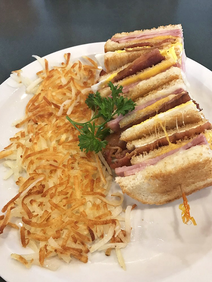 The club sandwich—architecture you can eat, where each layer tells its own delicious story stacked between perfectly toasted bread slices.