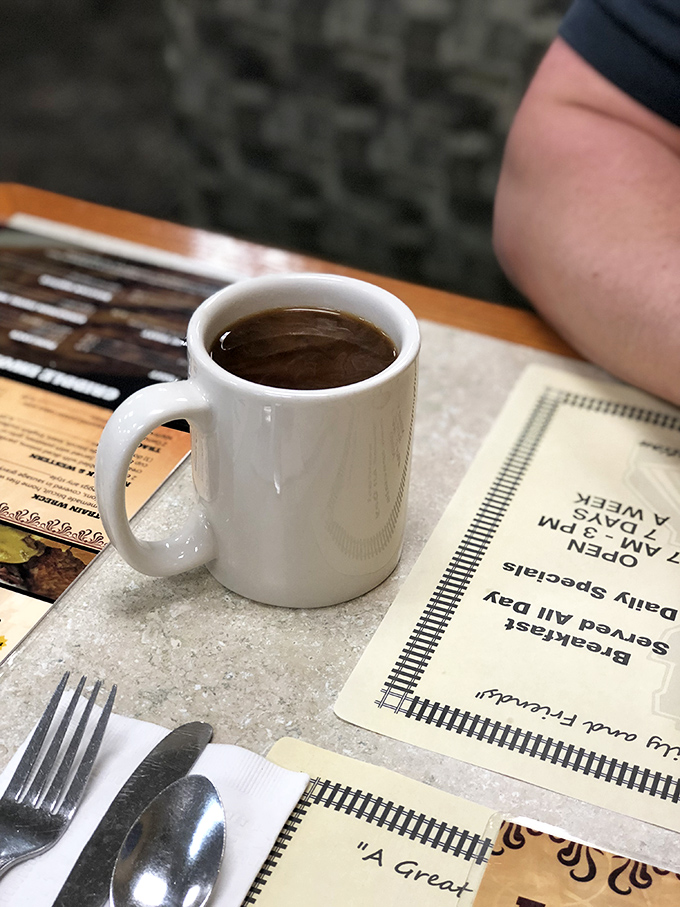 The humble coffee mug&mdash;unassuming vessel of morning salvation, sitting patiently beside silverware wrapped with the care of a grandmother's hug.