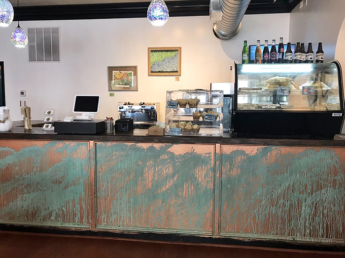 The counter's distressed turquoise finish adds a pop of artistic charm, while the pastry case tempts you with treats you definitely didn't come in for.