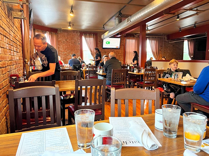 A bustling dining room where strangers become temporary breakfast companions, united by the universal language of "pass the syrup."