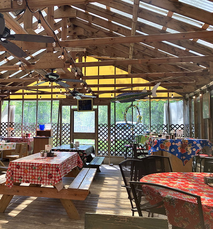 The covered patio area feels like dining in a treehouse for grown-ups, where checkered tablecloths and string lights create vacation vibes year-round.