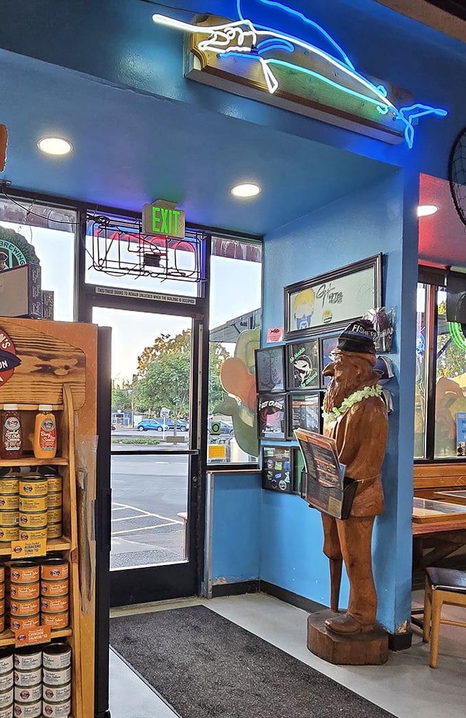 That wooden fisherman statue isn't just decoration&mdash;he's the silent guardian of seafood excellence. The blue walls and neon fish create a maritime wonderland.