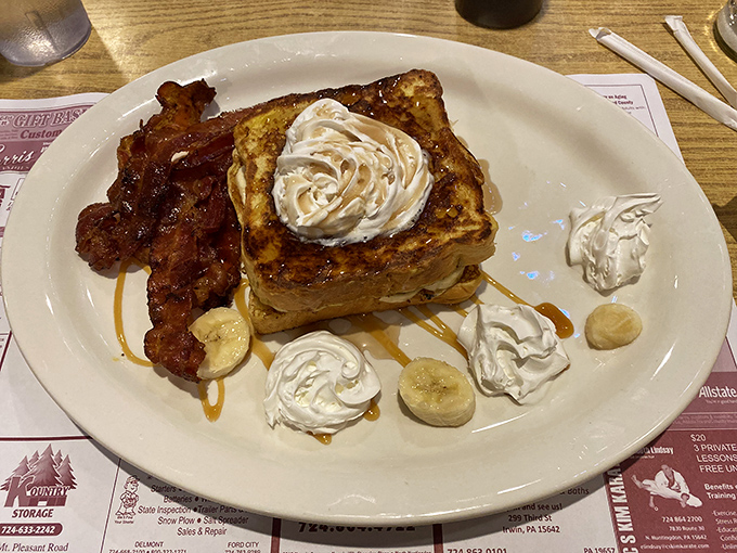 French toast that makes you question every other breakfast decision you've ever made &ndash; crowned with whipped cream and surrounded by bacon because balance is important.