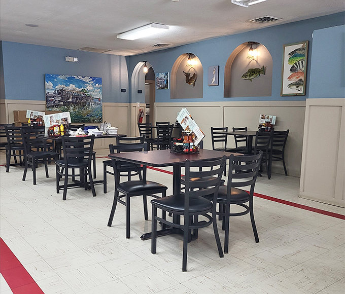 Blue walls, fish art, and tables waiting for hungry diners. The calm before the delicious storm of seafood platters arrives.