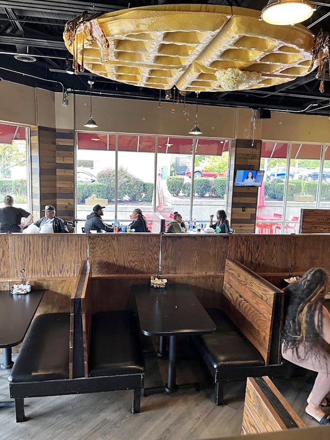Booth seating beneath the watchful eye of The Great Waffle in the Sky&mdash;breakfast theater at its finest.