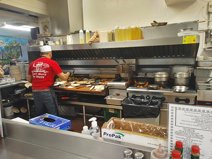 The kitchen ballet in full swing. That flat-top grill has probably seen more action than most Broadway stages.