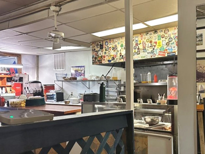 A kitchen wall plastered with stickers tells stories of visitors past. This isn't corporate d&eacute;cor&mdash;it's a community scrapbook built over decades.